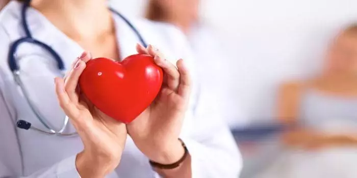 Pigelæge holder et hjerte i hænderne