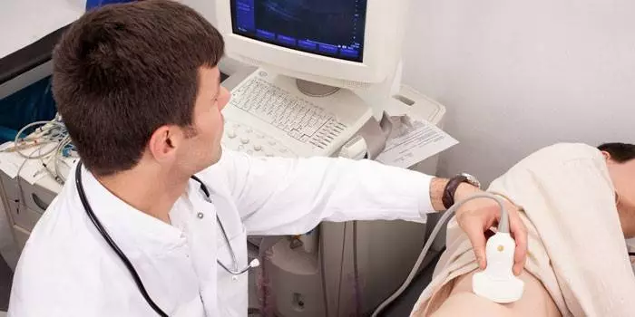 Un médico realiza un examen de ultrasonido de los riñones.