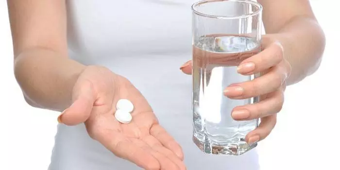 Pil di tapak tangan dan segelas air