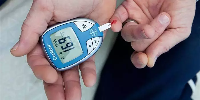 Woman measures blood sugar with glucometer