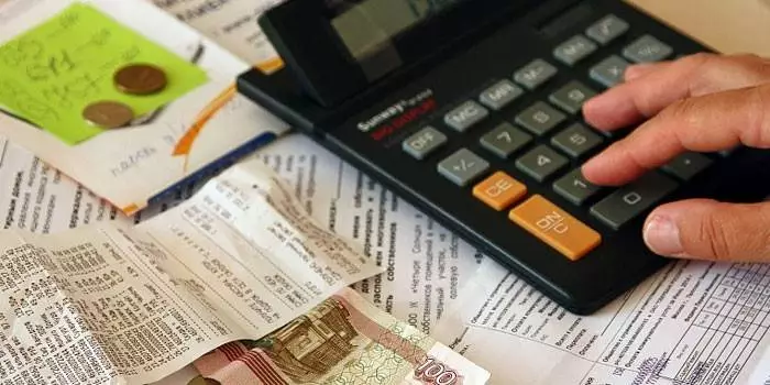 Contas de serviços públicos, dinheiro e calculadora