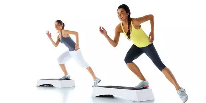 Girls do aerobics on a step platform