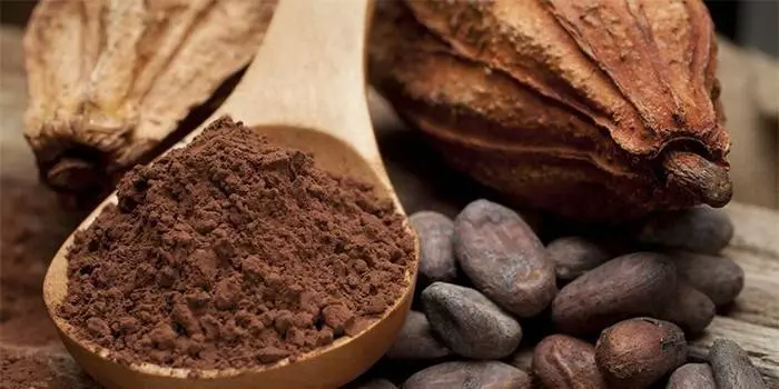 Bir qaşıqda kakao dənələri və toz