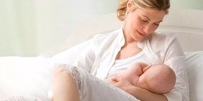 स्त्री बाळाला स्तनपान देत आहे