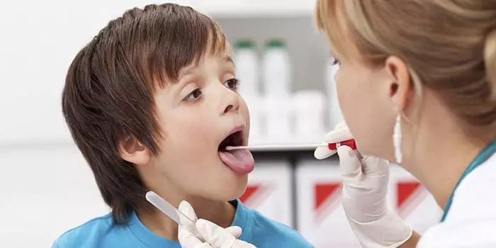 Un metge li pren un hisop a la gola d’un nen