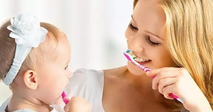 Mom and baby brush their teeth to avoid sore lips