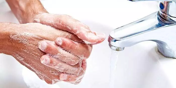 El hombre se lava las manos con jabón
