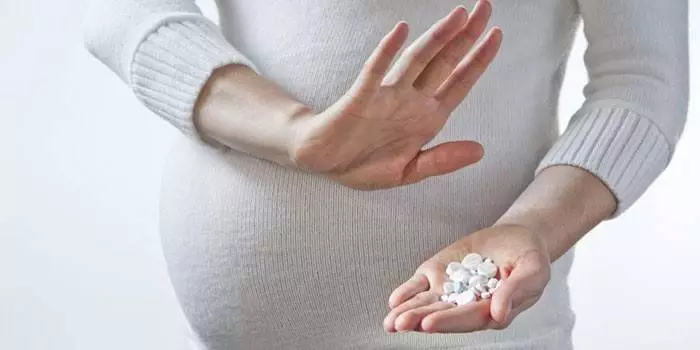 Grūtniece ar tabletēm rokā