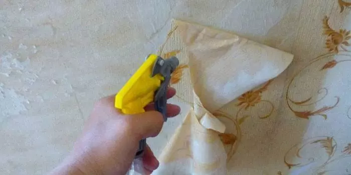 Moistening wallpaper with water from a spray spray