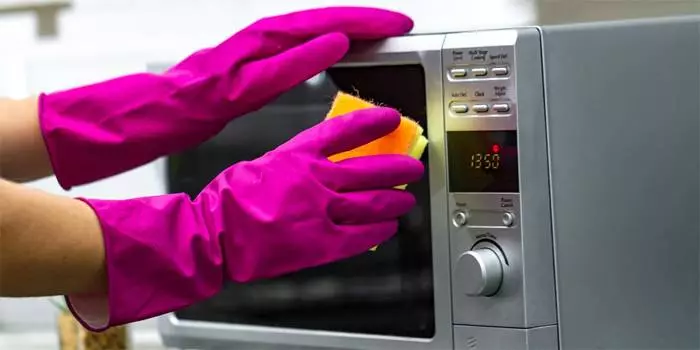 Wanita mencuci microwave