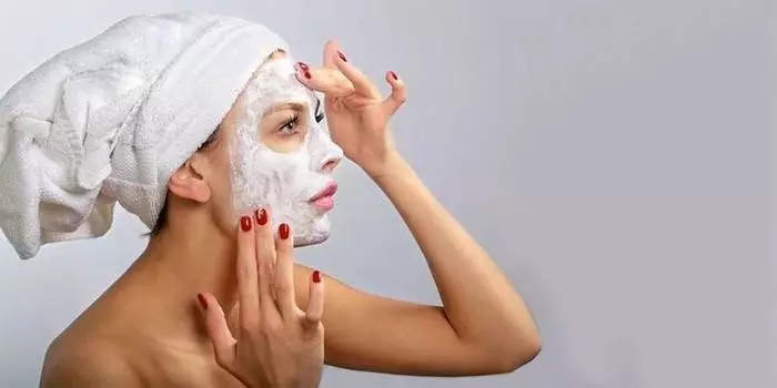 Menina aplicando uma máscara facial de proteína