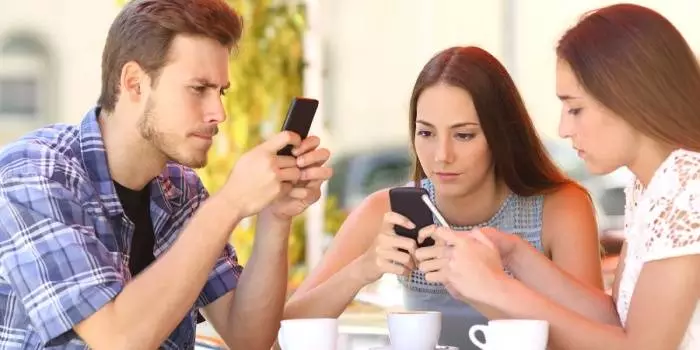 Unga människor med smartphones i sina händer